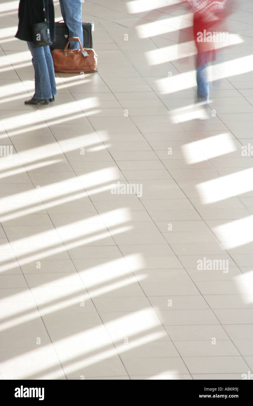 people standing in airport with luggage with person walling through ...
