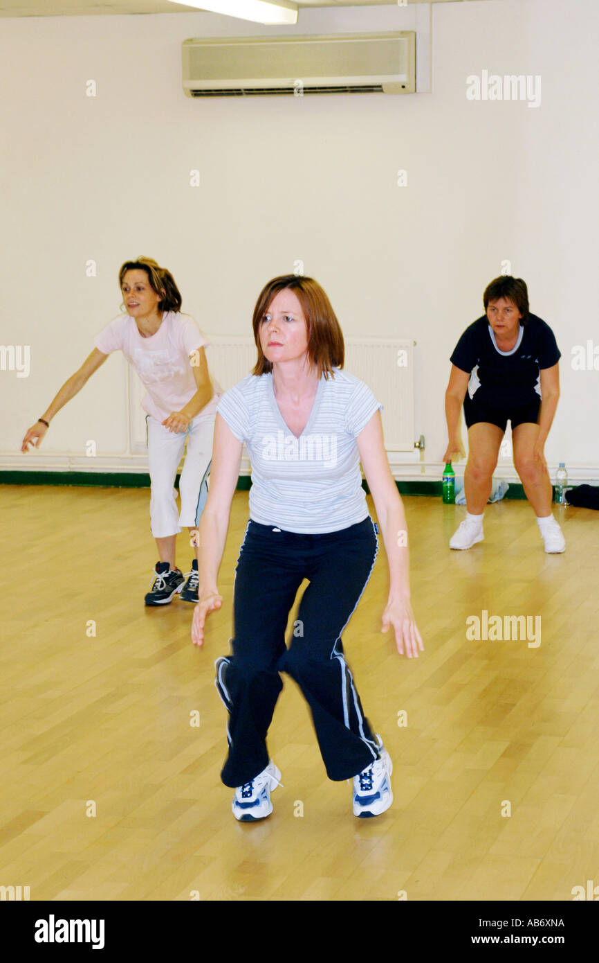 Females doing twist-down exercises in a workout class Stock Photo - Alamy