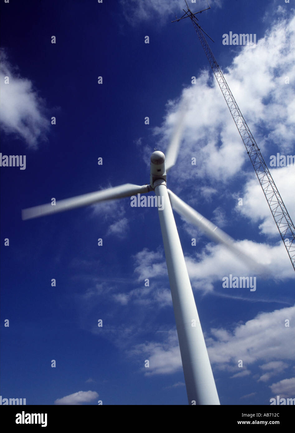 WIND TURBINE AND COMMUNICATIONS ANTENNA AGAINST BLUE SKY Stock Photo ...