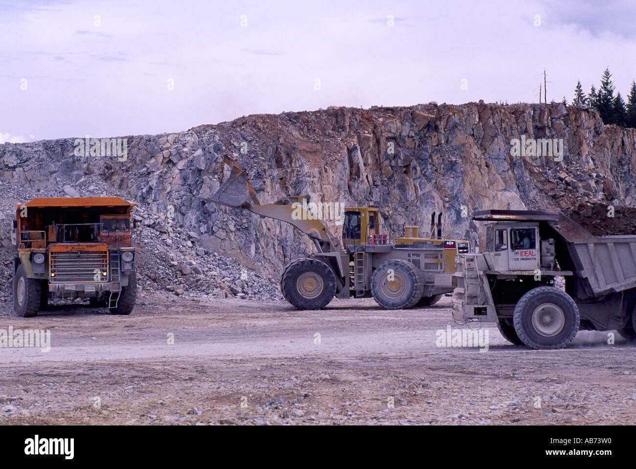 Front End Loader loading 100 Ton Mining Dump Trucks at Open Pit ...