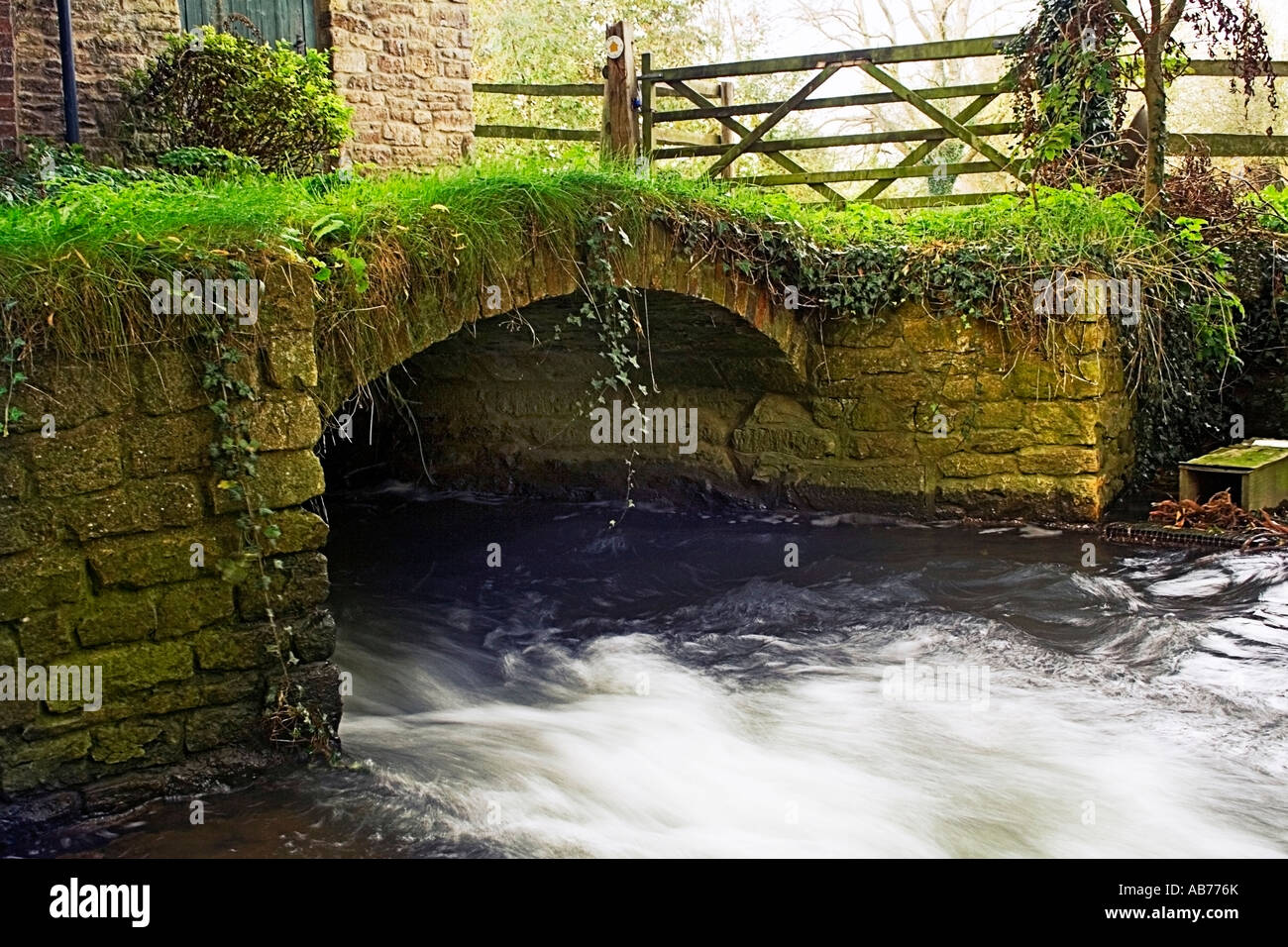 bridge over fast flowing river part of old mill house five bar gate to ...
