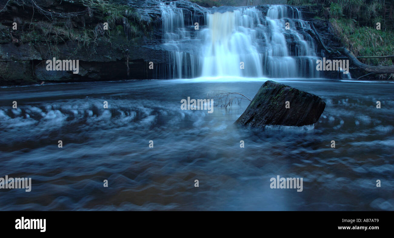Waterfall with swirling water and tree stump in foreground,Hamsterley ...