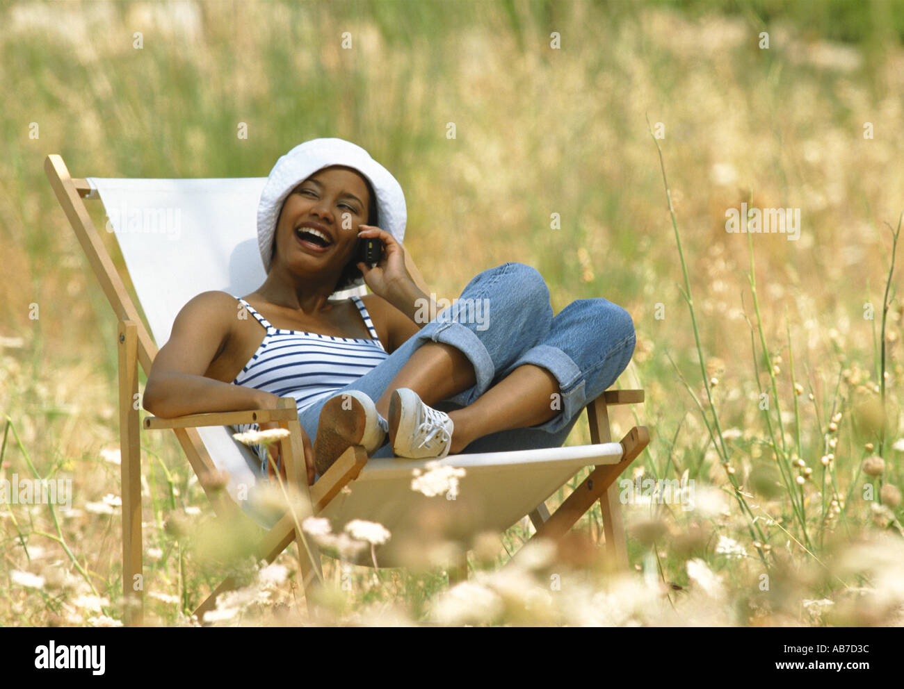 Woman reclining on deck chair Stock Photo - Alamy