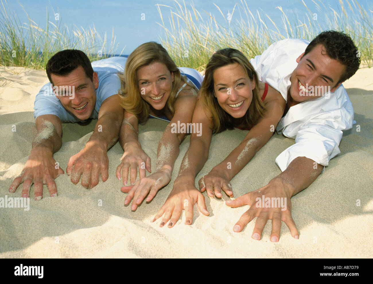 Two couples lying on beach hi-res stock photography and images - Alamy