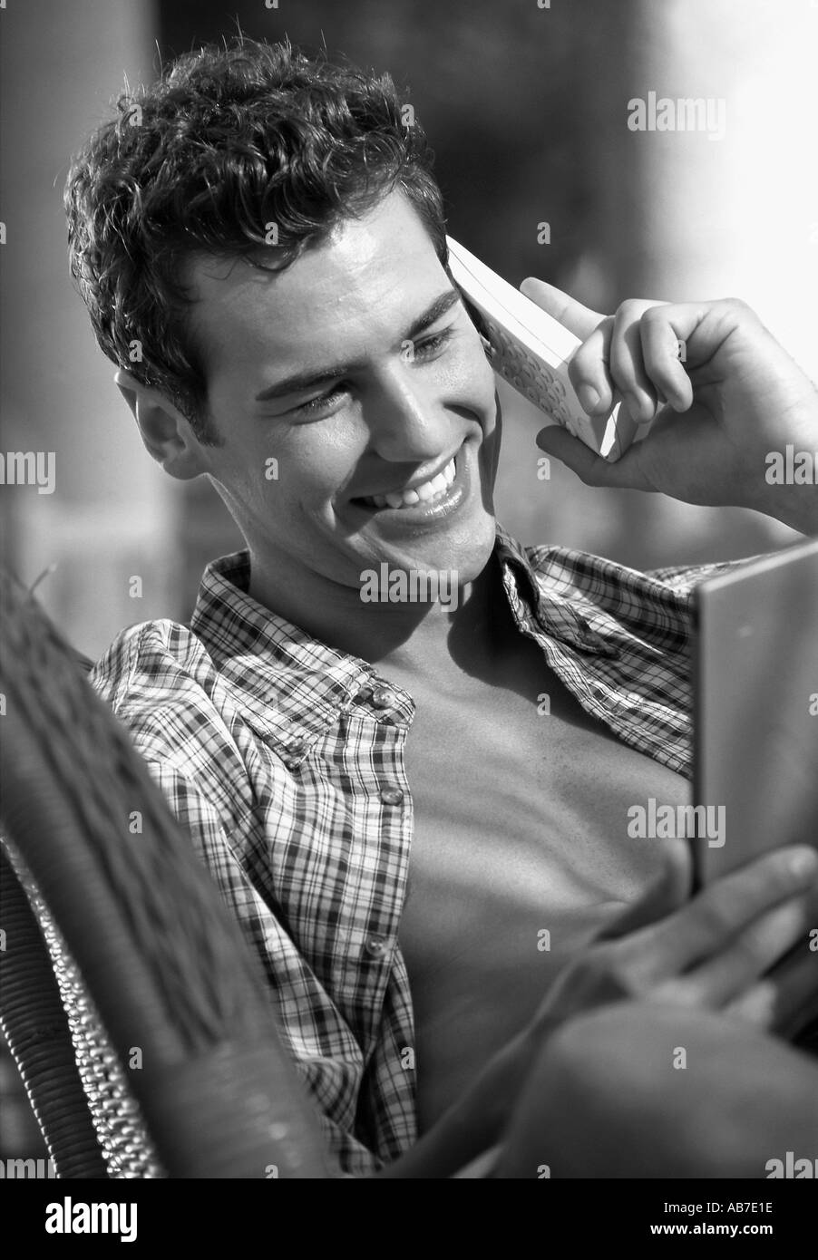Young man using phone holding Black and White Stock Photos & Images - Alamy