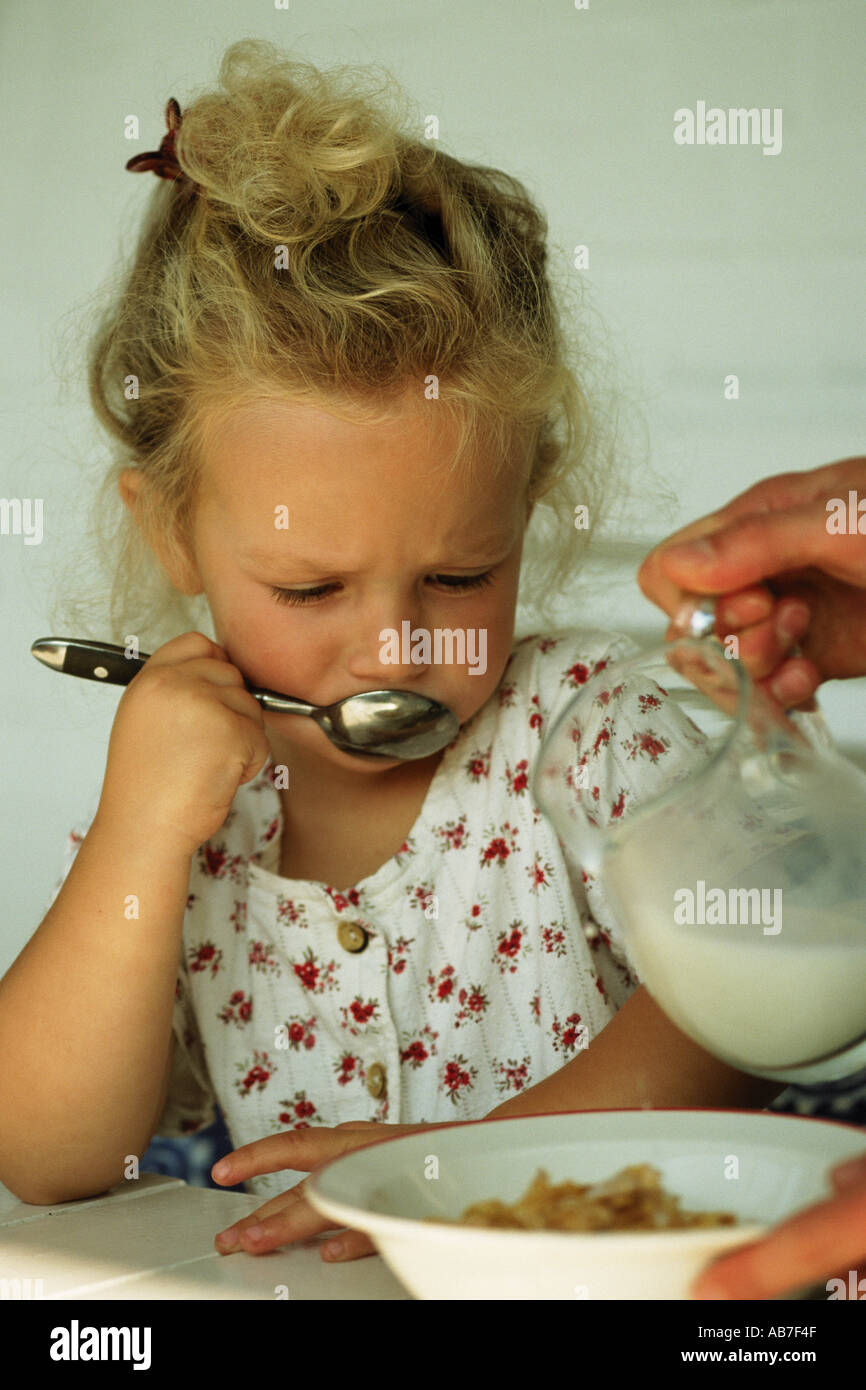 Girl eating cornflakes Stock Photo - Alamy