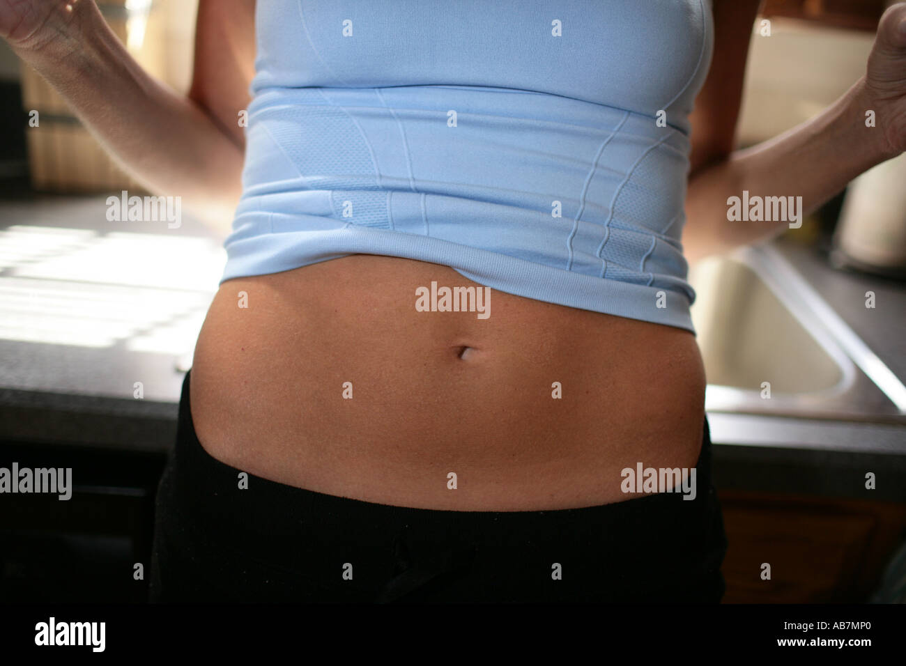 Woman with flat tummy in kitchen healthy eating concept Stock Photo - Alamy