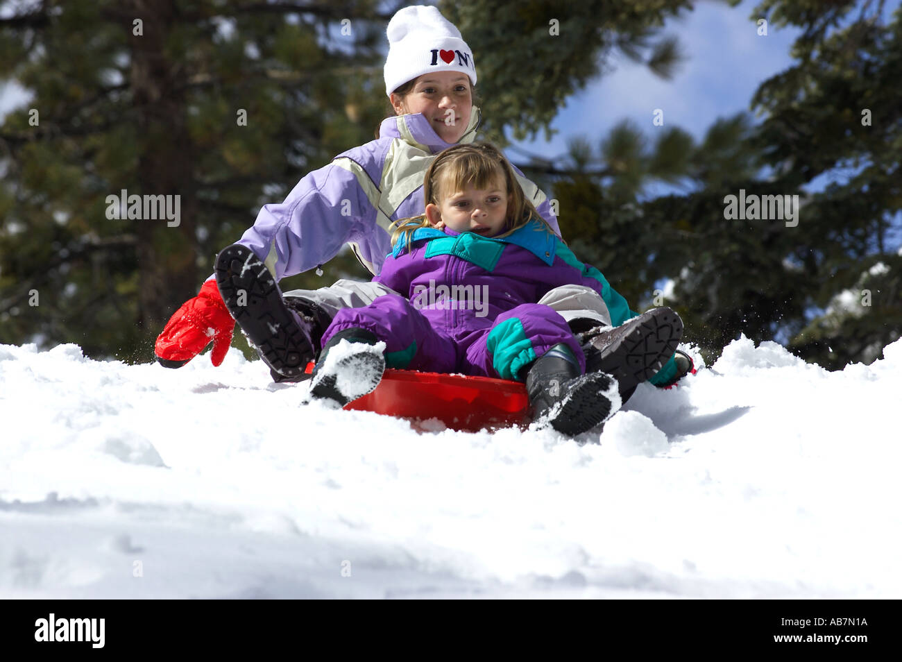 two girls on snow sled Stock Photo - Alamy