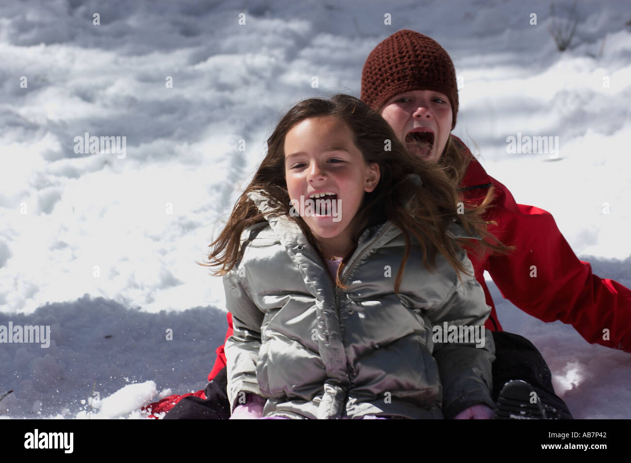 girls on snow sled screaming Stock Photo - Alamy