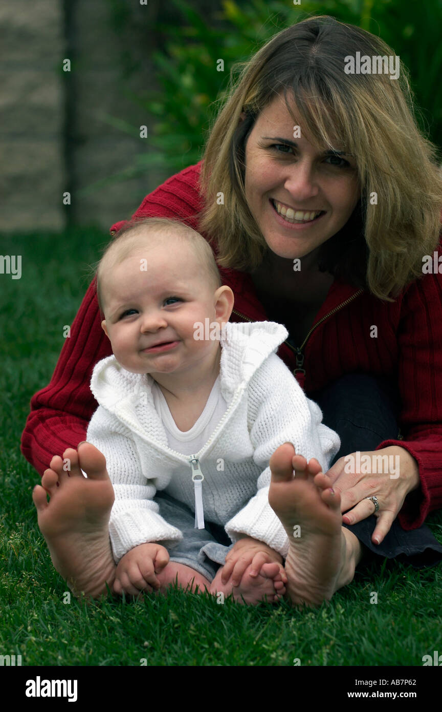 mother and baby sitting on grass Stock Photo - Alamy