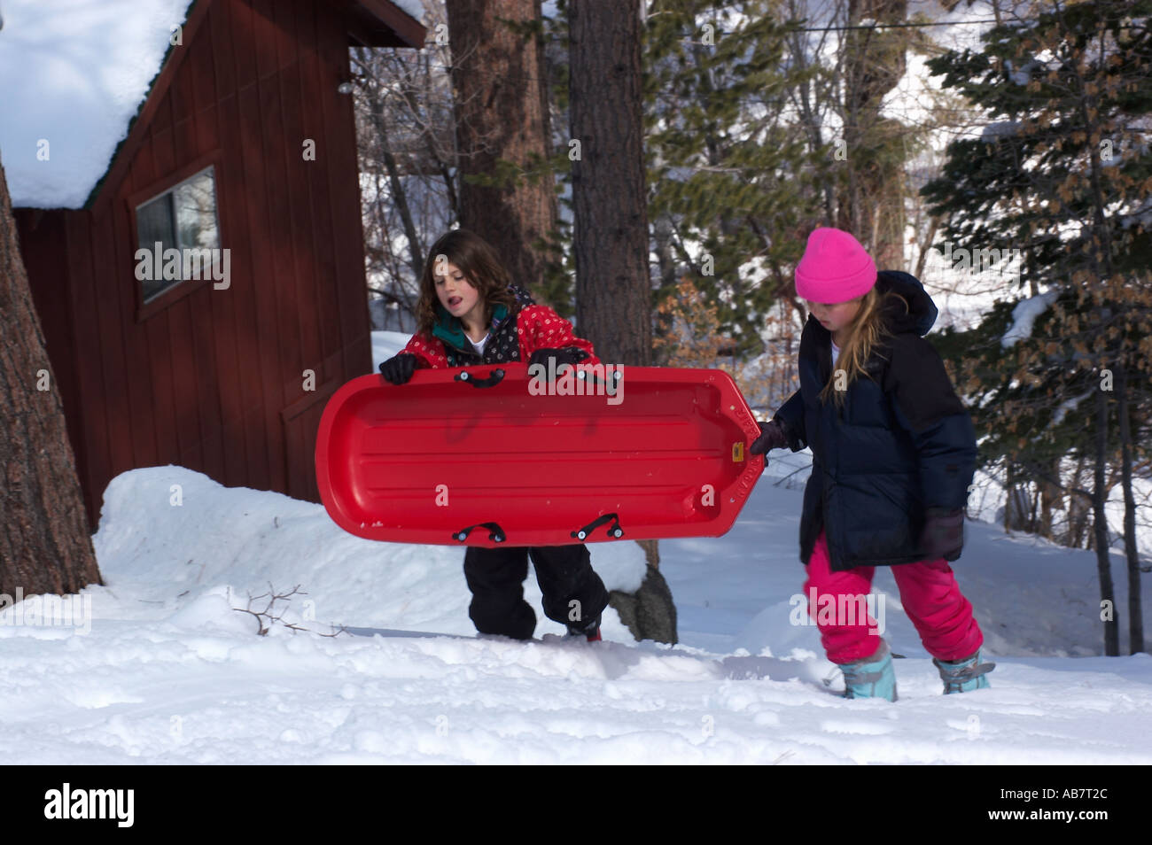 girls carrying sled Stock Photo - Alamy