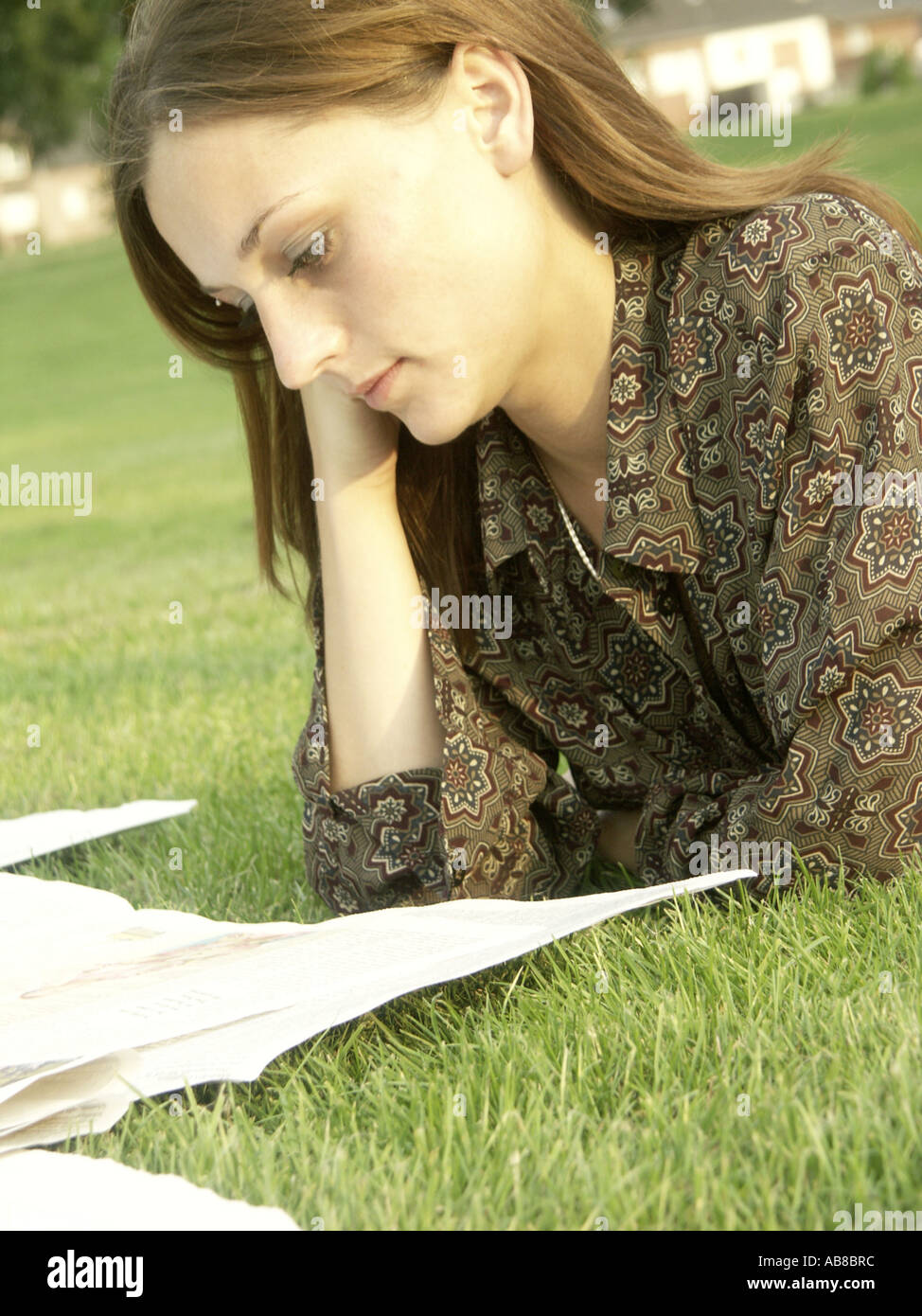 woman lying on meadow reading newspaper Stock Photo - Alamy