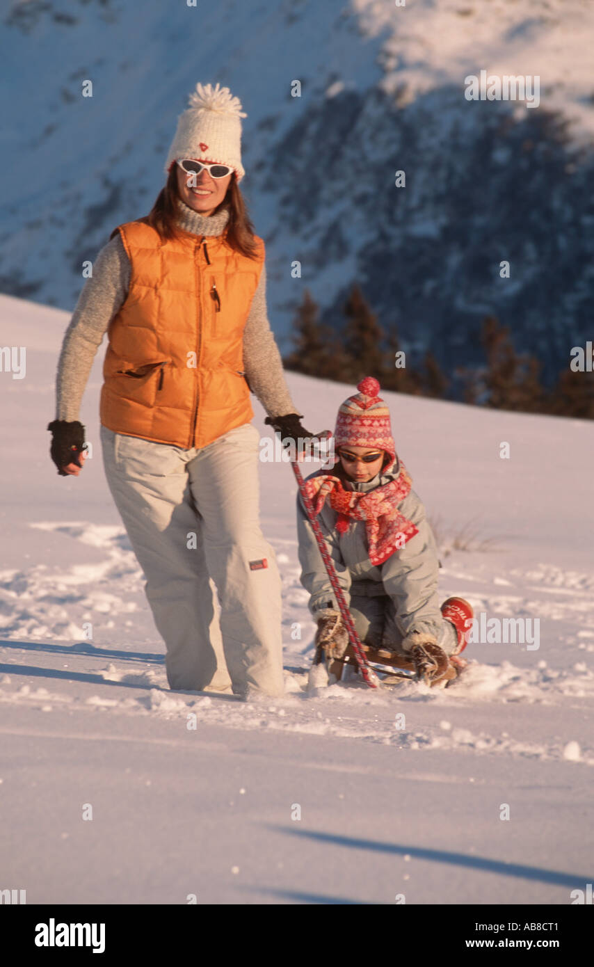 woman pulling sledge with child sitting on it, France Stock Photo - Alamy