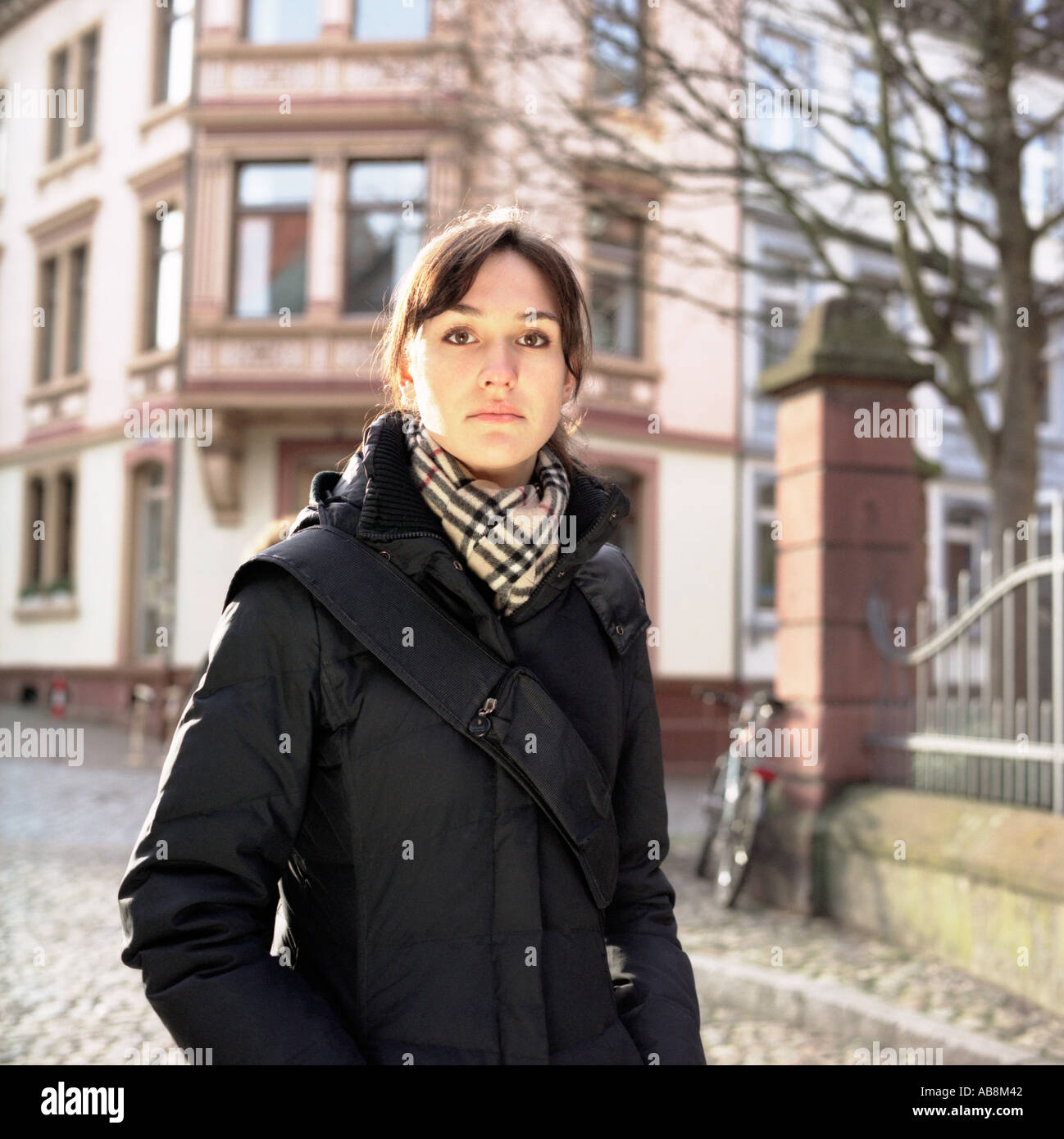 portarit of a young girl wearing black overcoat on the street Stock ...