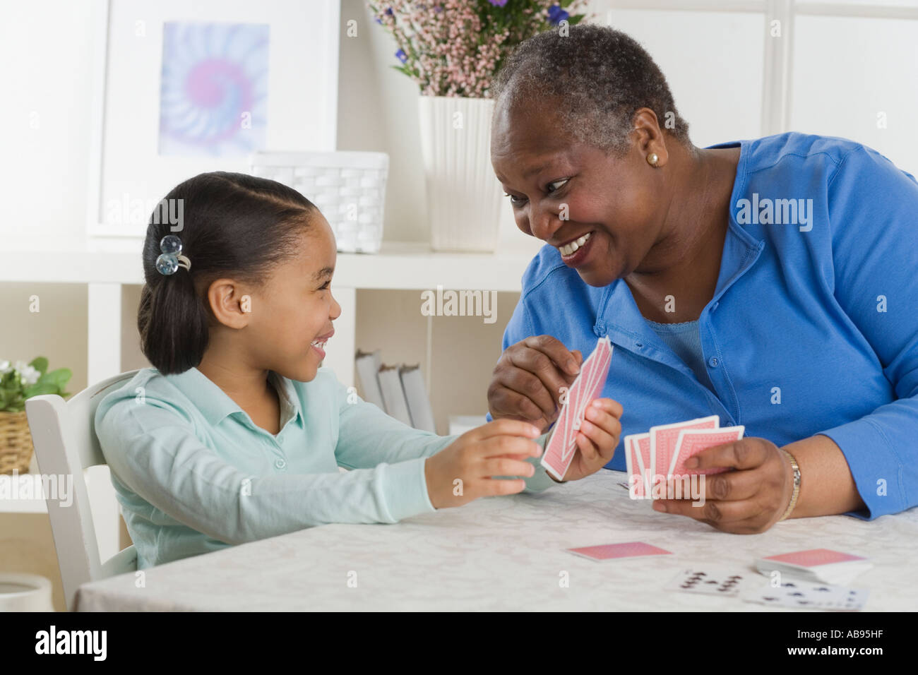Senior woman playing cards with her granddaughter Stock Photo - Alamy