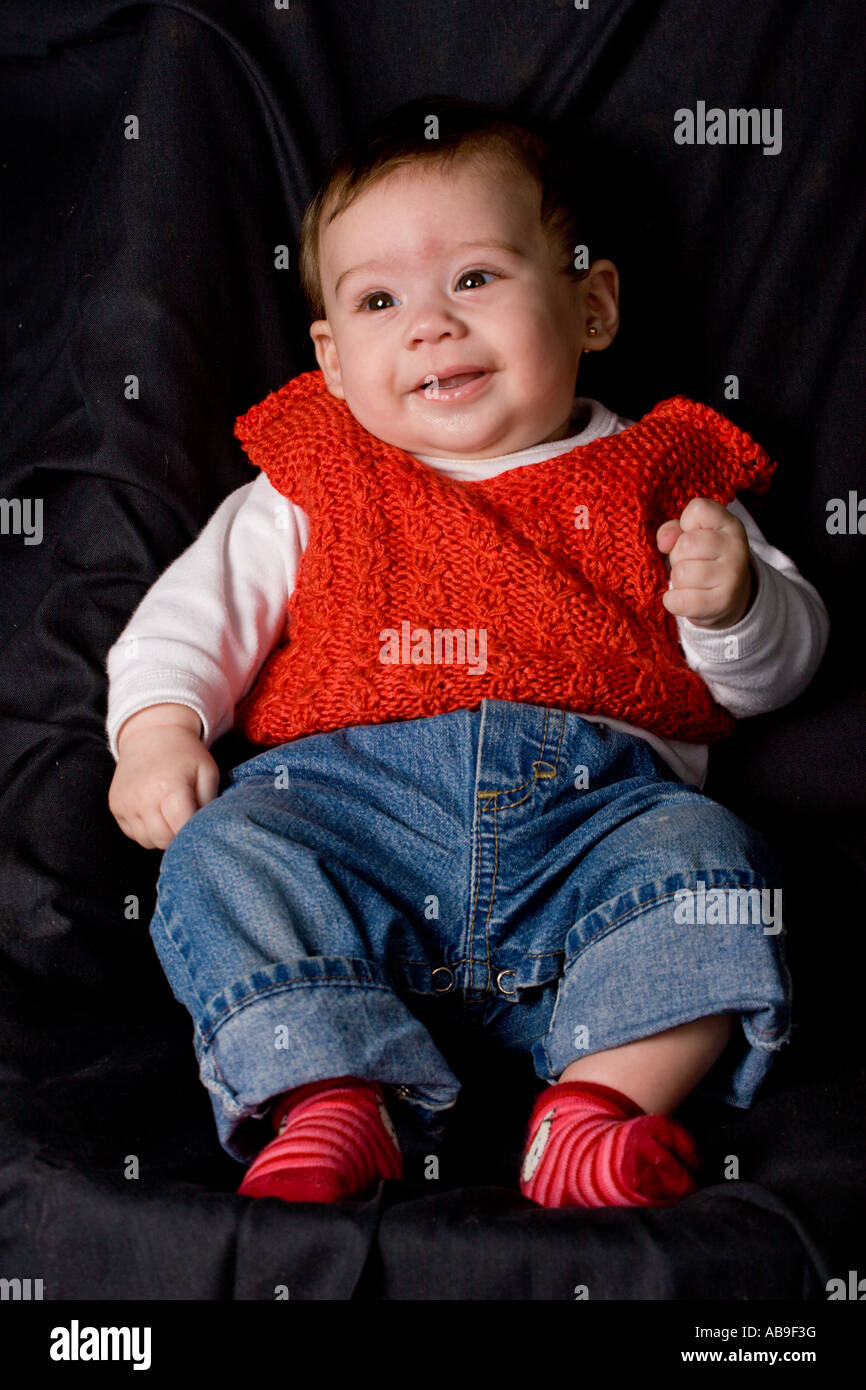 Little baby girl sitting down isolated over a black background Stock ...