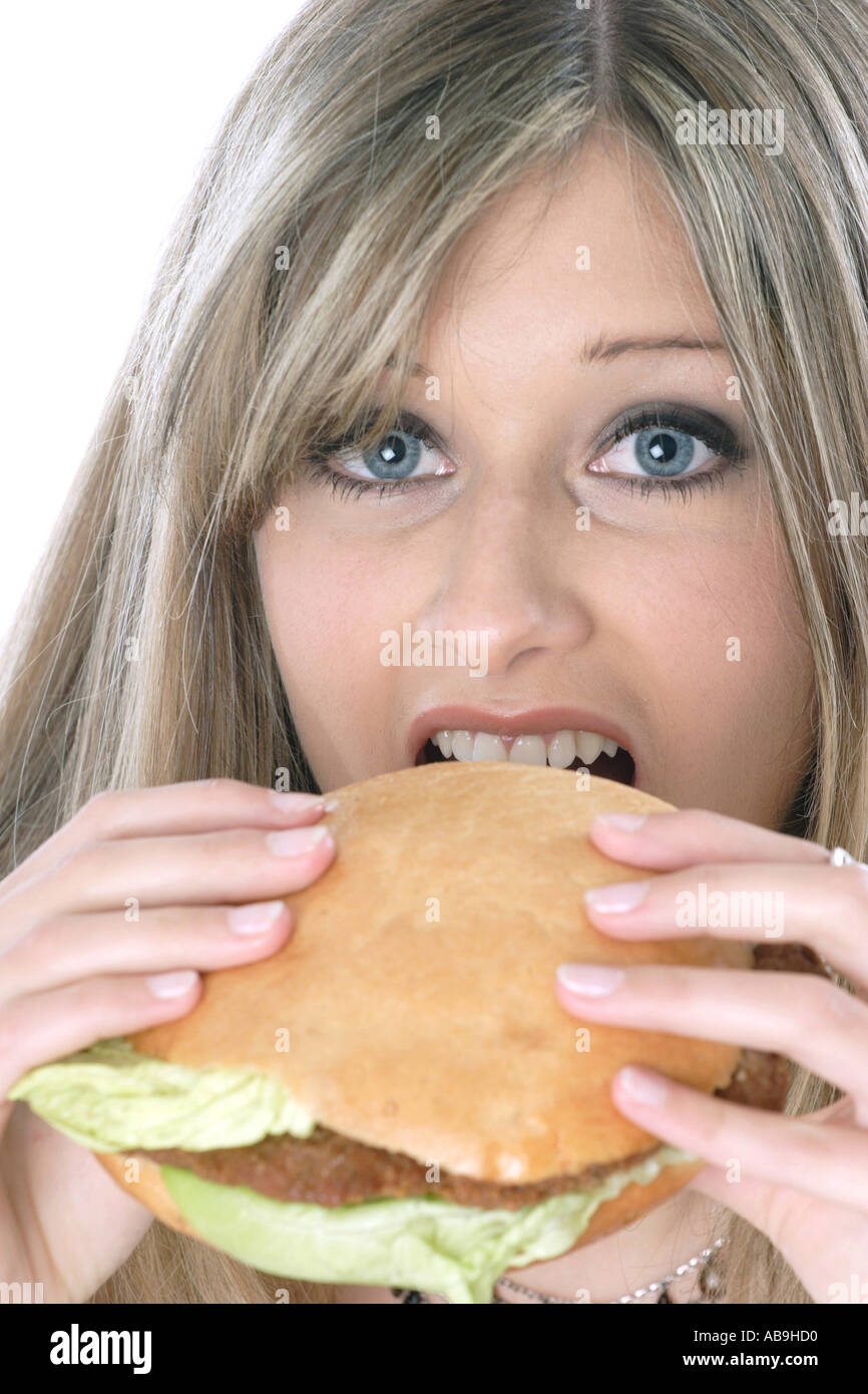 blond woman biting in burger Stock Photo - Alamy