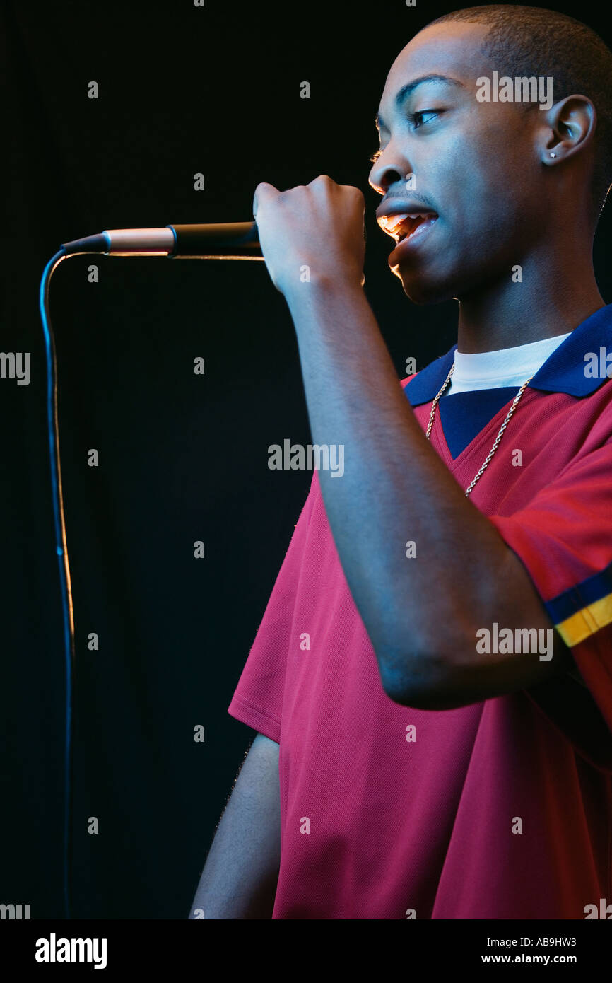 Young man singing into a microphone Stock Photo - Alamy