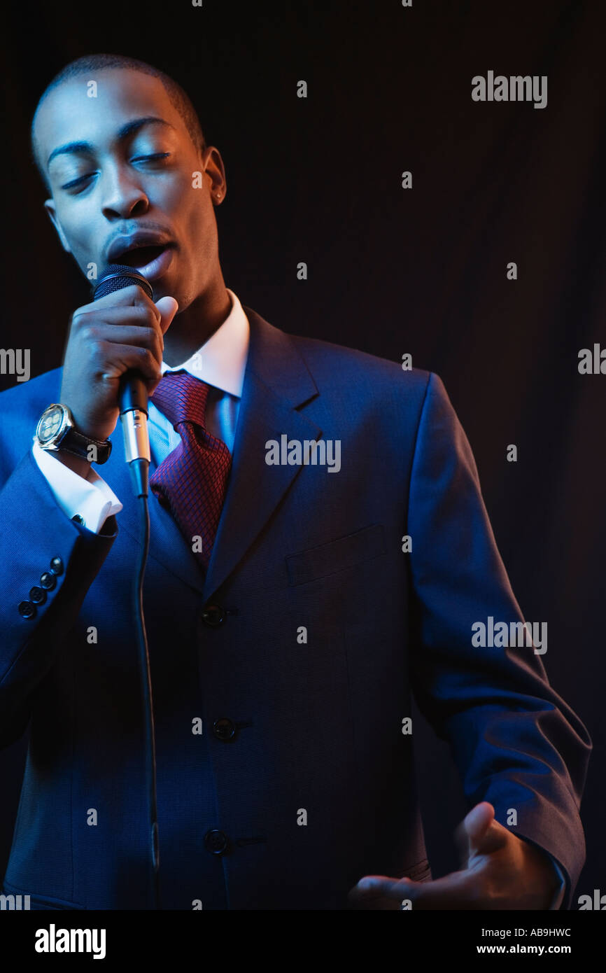 Businessman singing into a microphone Stock Photo - Alamy