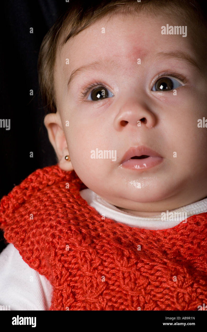 Baby girl looking up with a serious face Stock Photo - Alamy