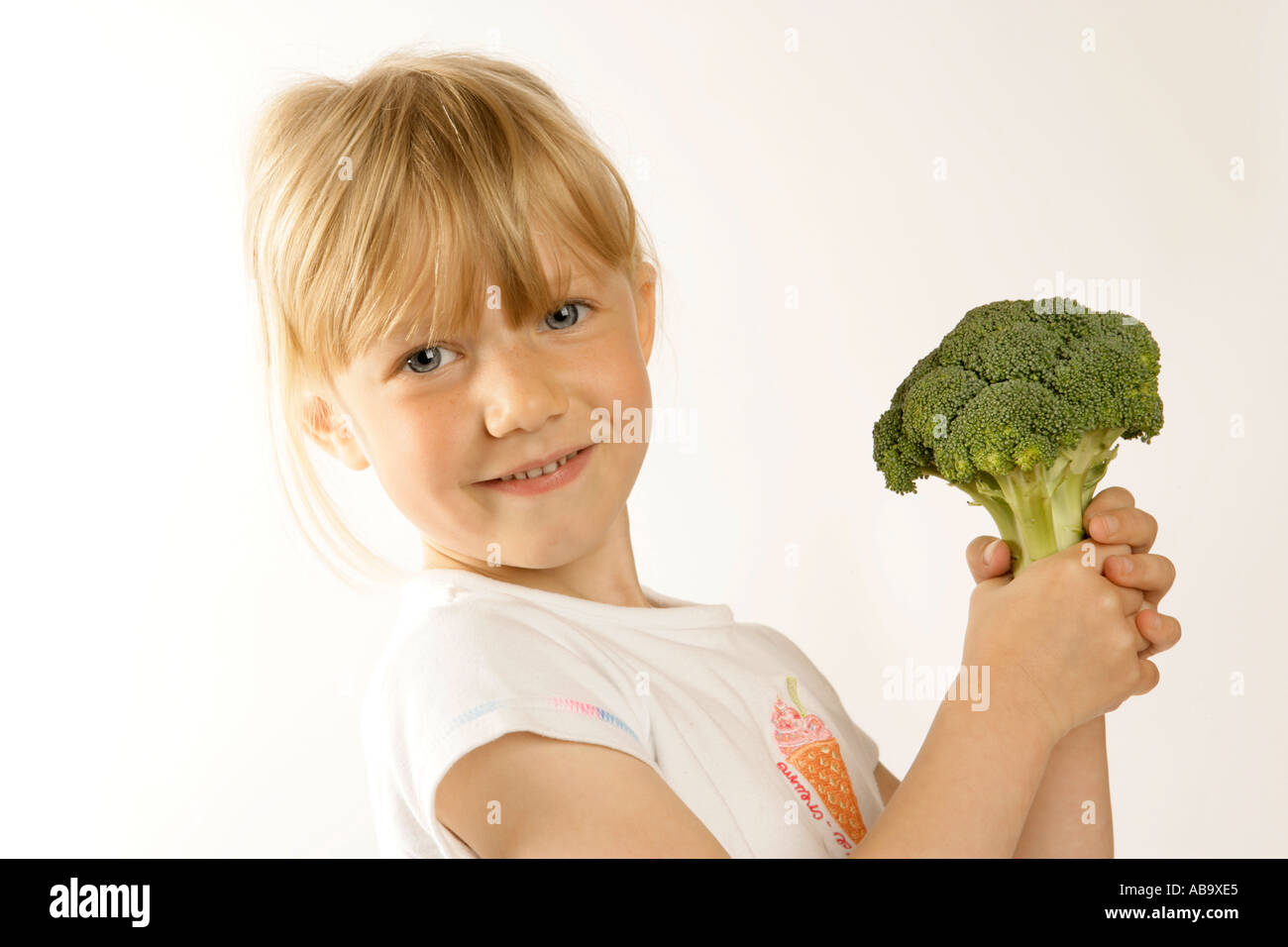 Young girl with a large head of Broccoli Promoting eating vegetables as ...