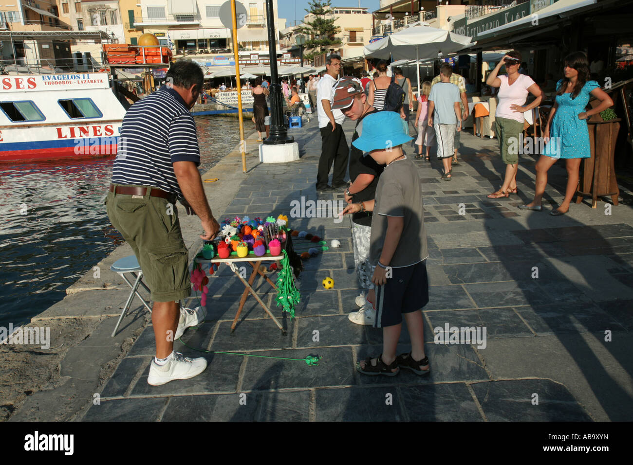 Children looking at toys at the old Venetian harbour in Chania, Crete ...