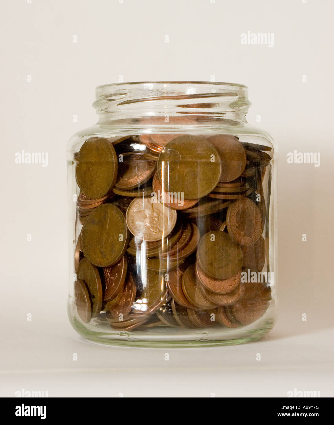 Glass jam jar filled with coins against a plain background Stock Photo ...