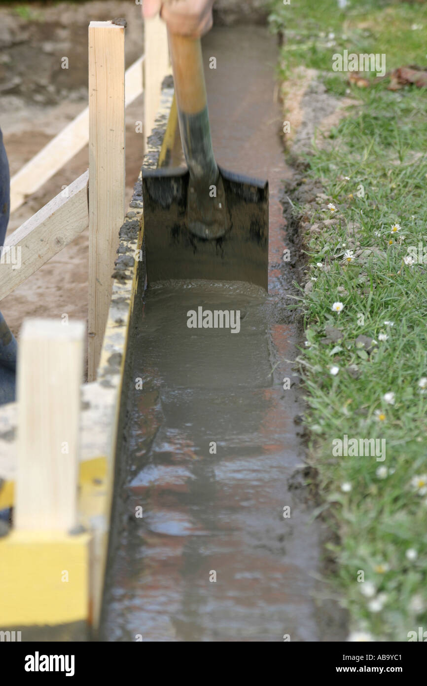 Using a spade to level out wet concrete in a form Stock Photo - Alamy