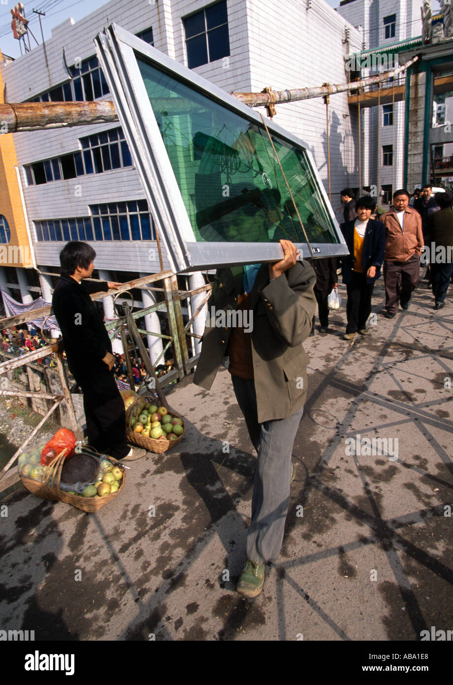 Man carrying sliding glass doors across bridge transport commerce ...