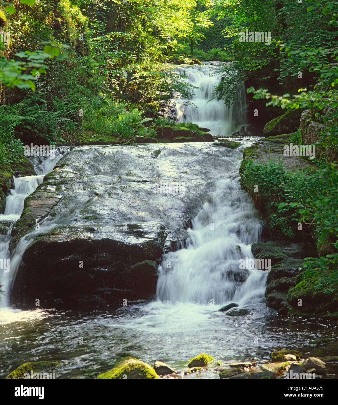 Double waterfall at Watersmeet with large black rock in centre of lower ...