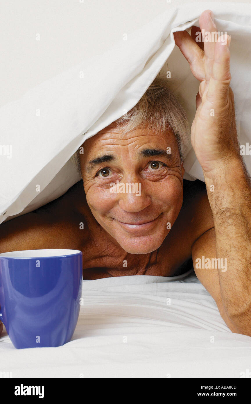 Man under duvet Stock Photo - Alamy