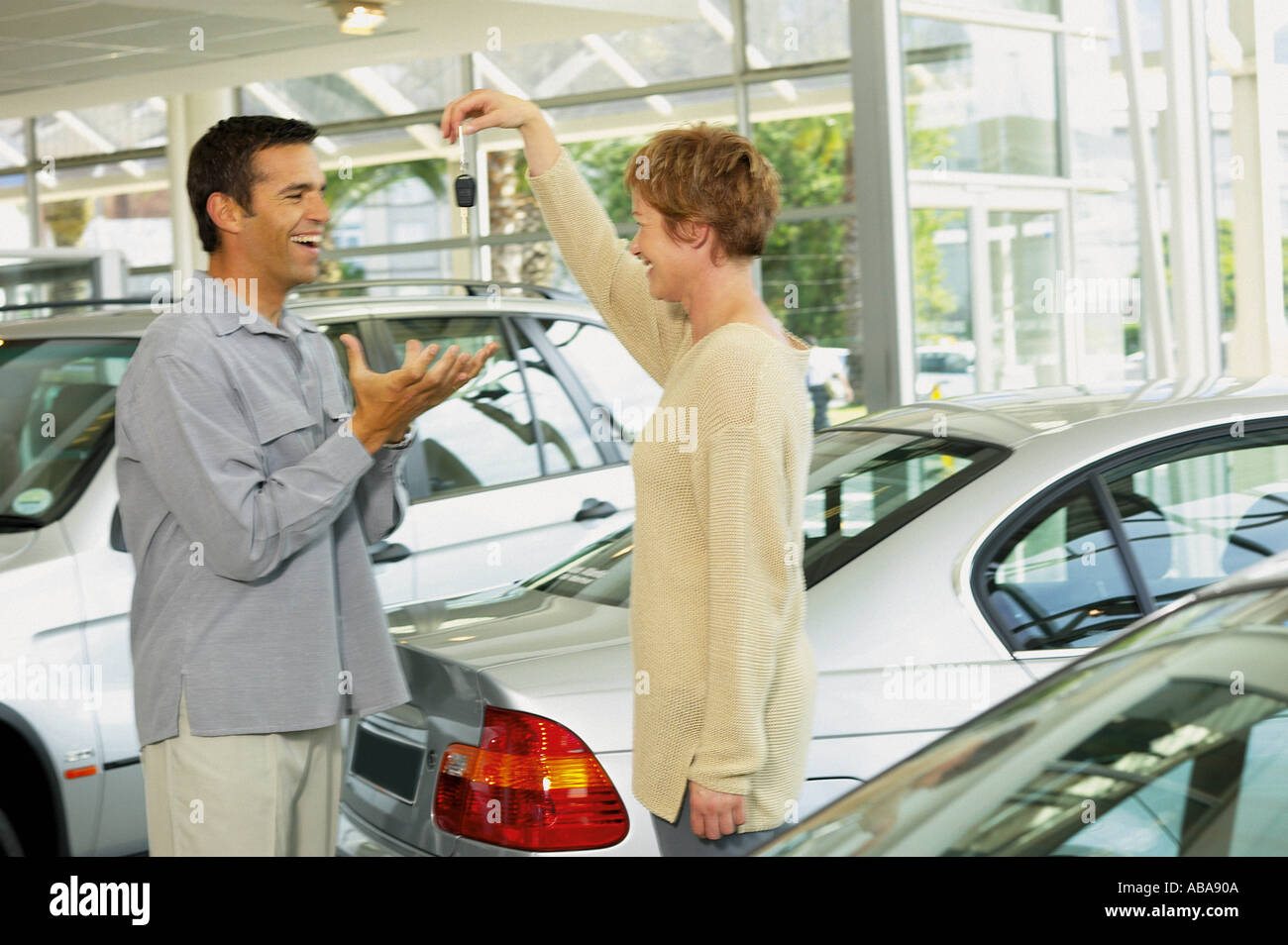 Woman passing keys to man Stock Photo - Alamy