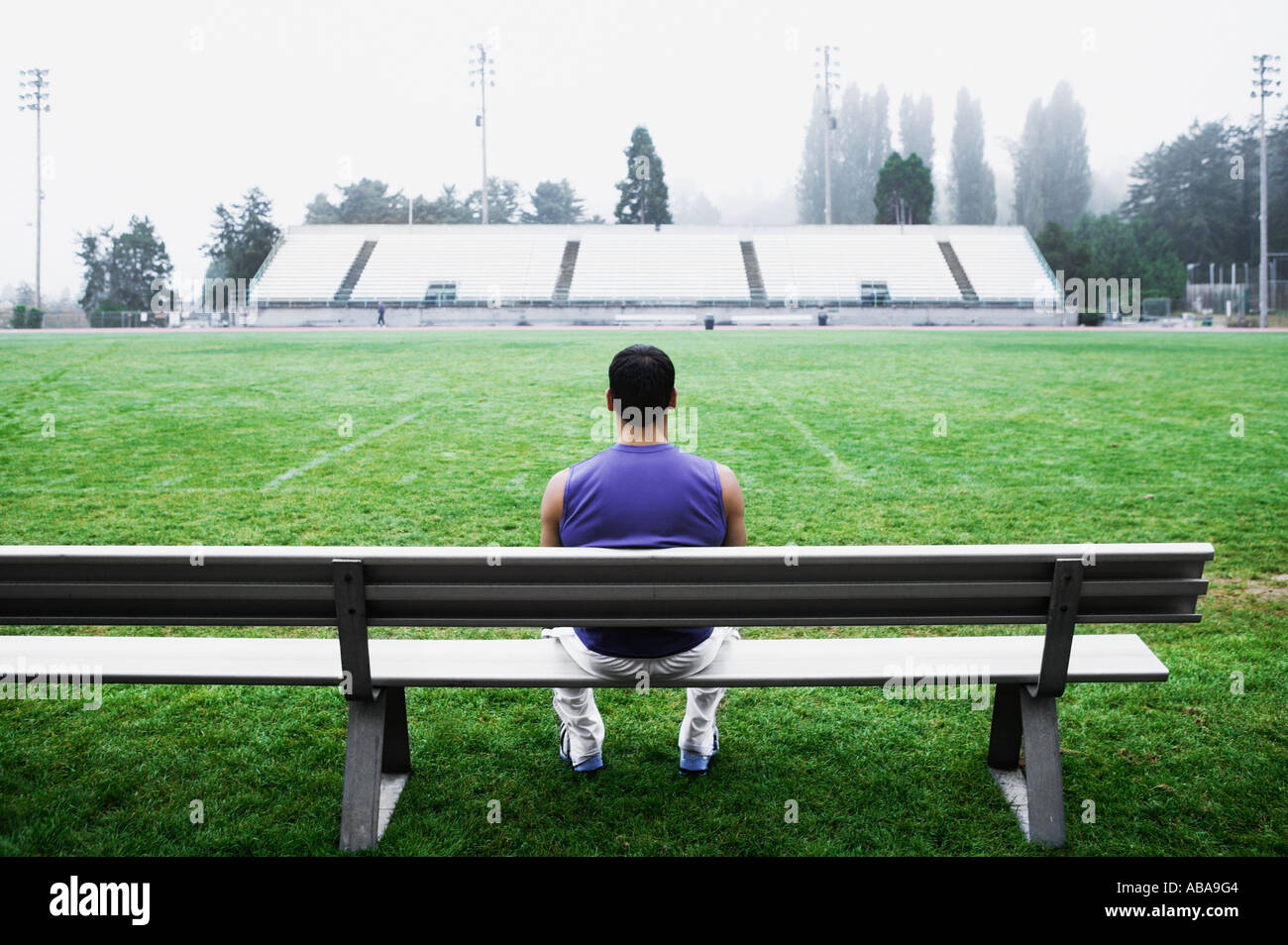 Male athlete sitting on bench Stock Photo - Alamy