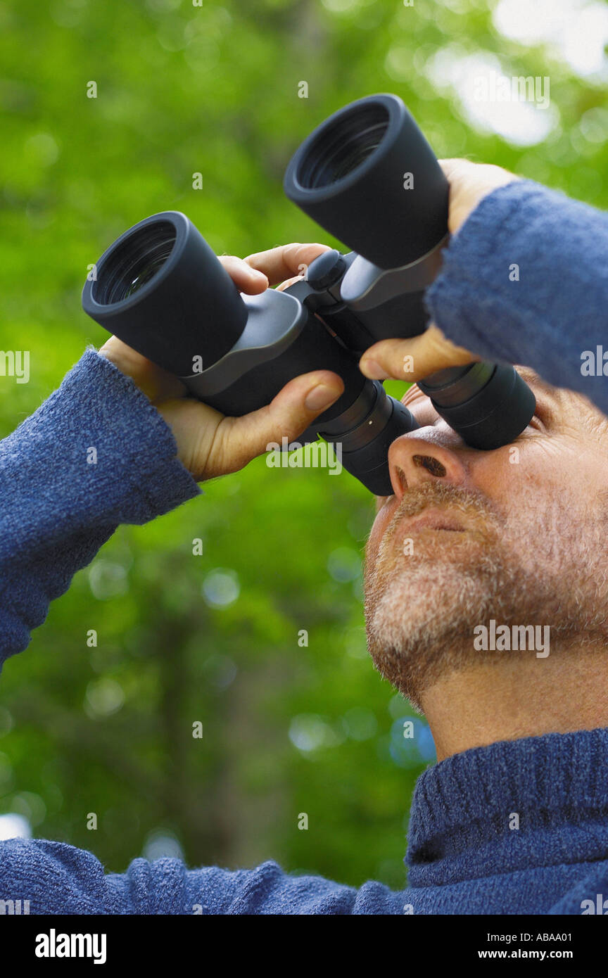 Man looking through binoculars Stock Photo - Alamy