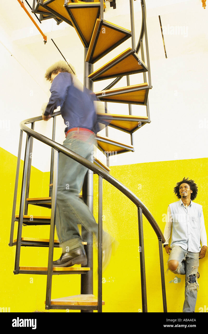 Man going up spiral stairs Stock Photo - Alamy