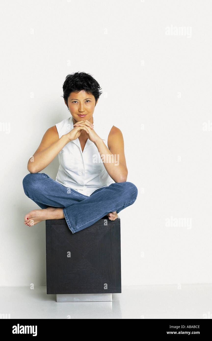 Woman sitting on stool Stock Photo - Alamy