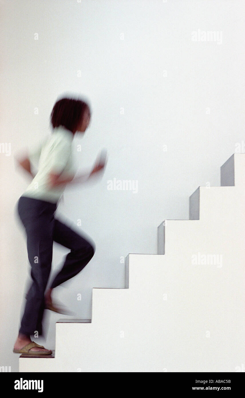 Woman running upstairs Stock Photo - Alamy