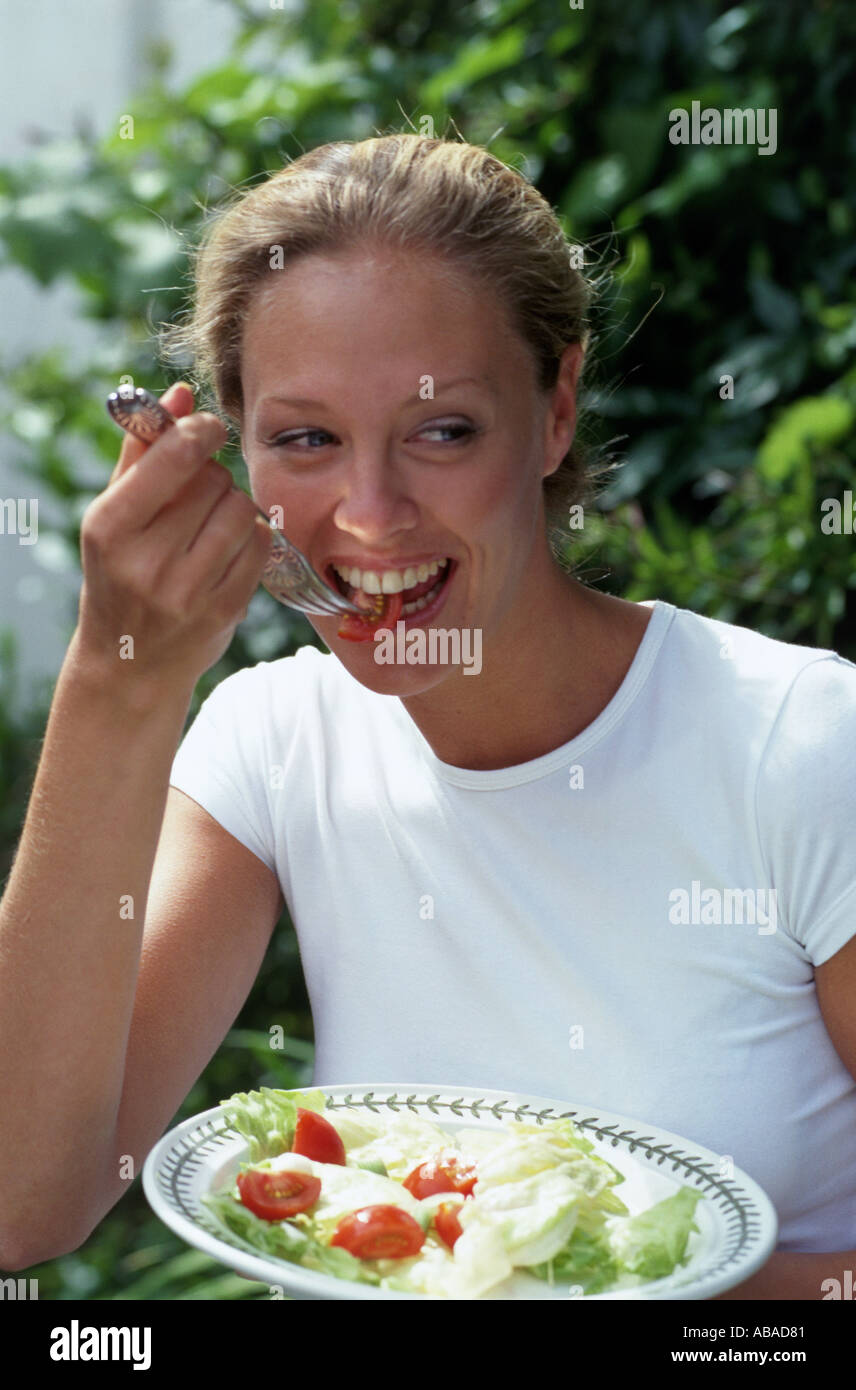 Girl eating salad Stock Photo - Alamy