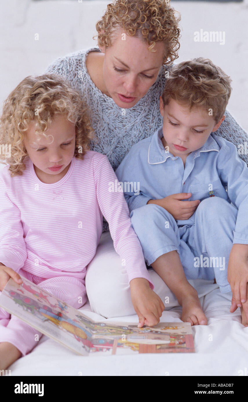 Mother and children reading Stock Photo - Alamy