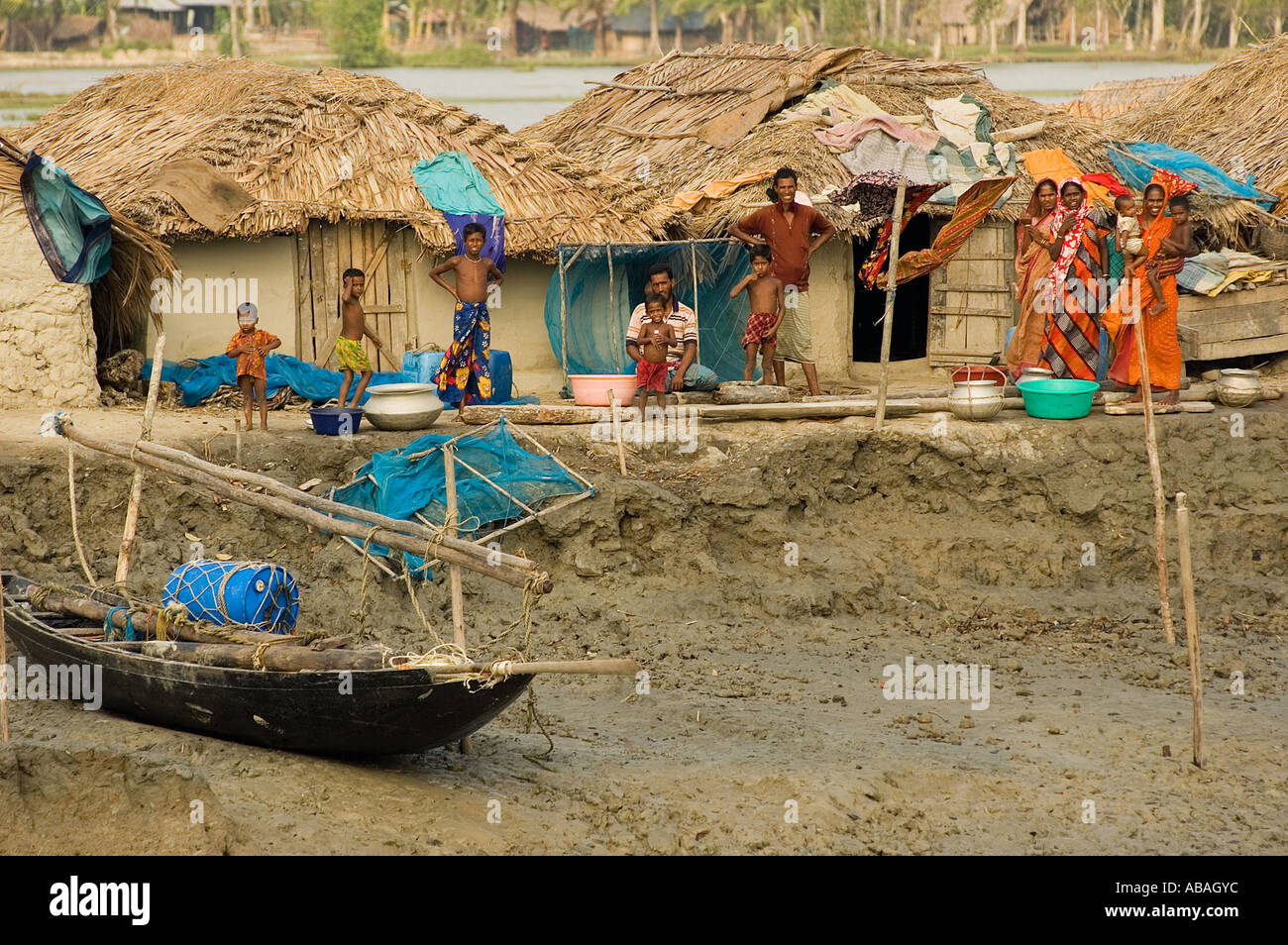 Poor fishing village and thatched roof mud houses along Passur River ...
