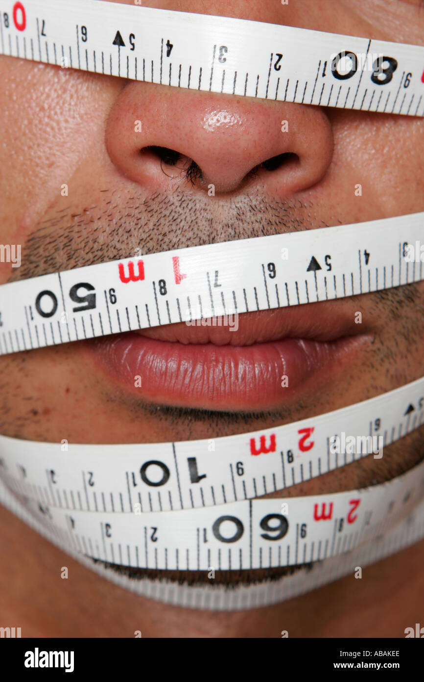close up of a mans face with tape measure wrapped arround Stock Photo ...
