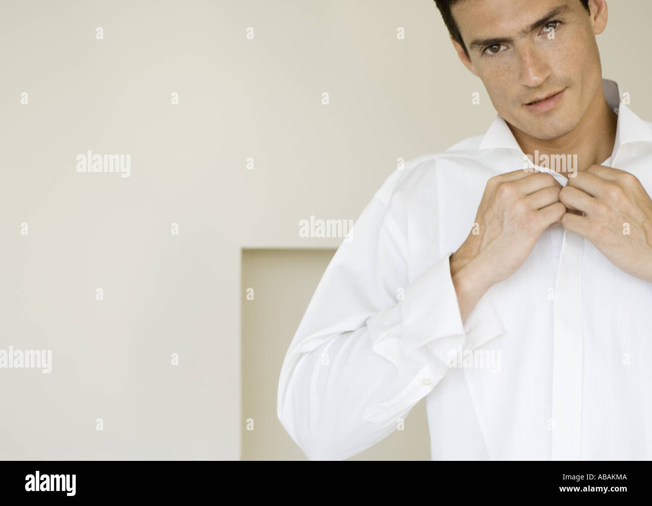 Man buttoning shirt Stock Photo - Alamy