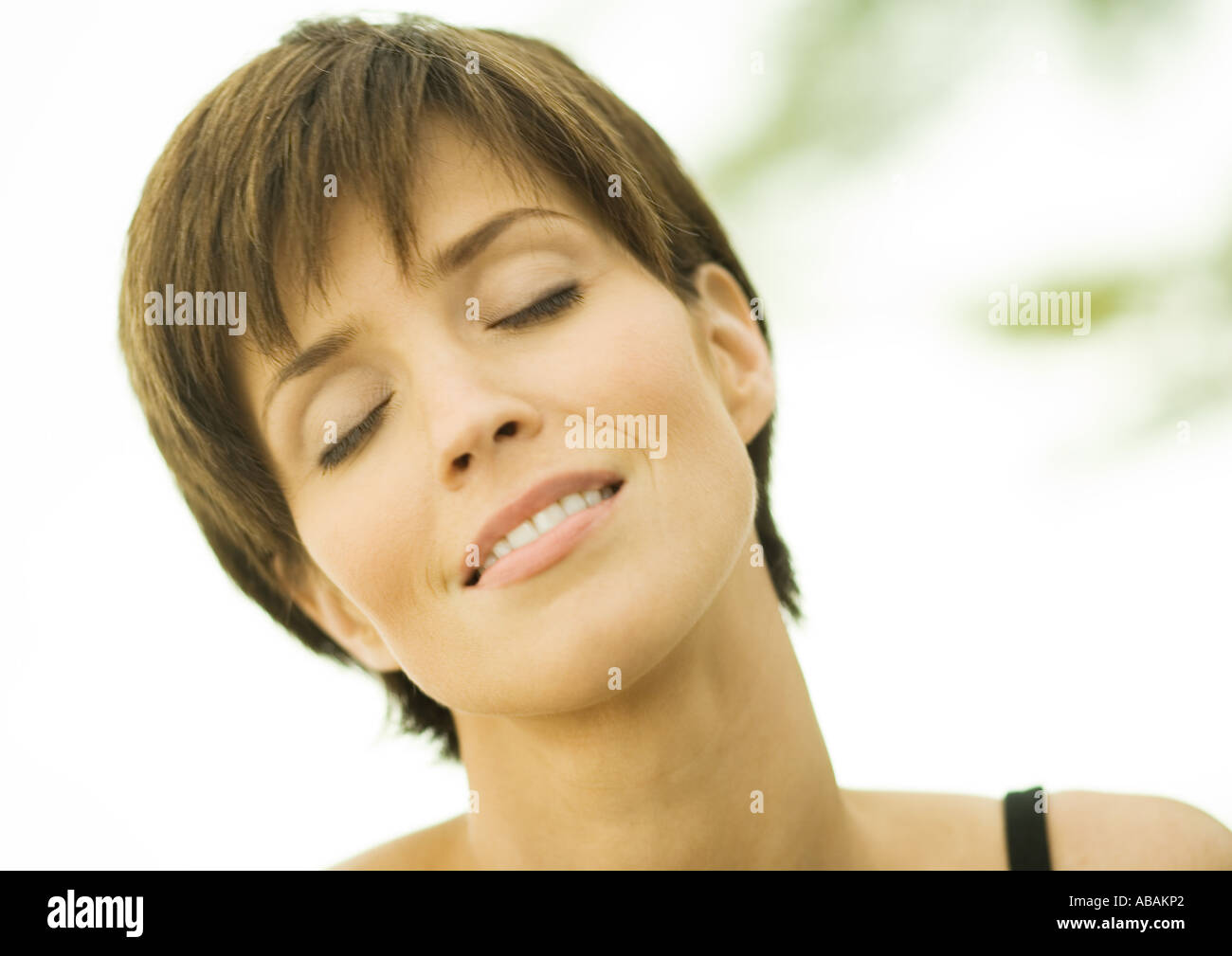 Woman shutting eyes and smiling Stock Photo - Alamy