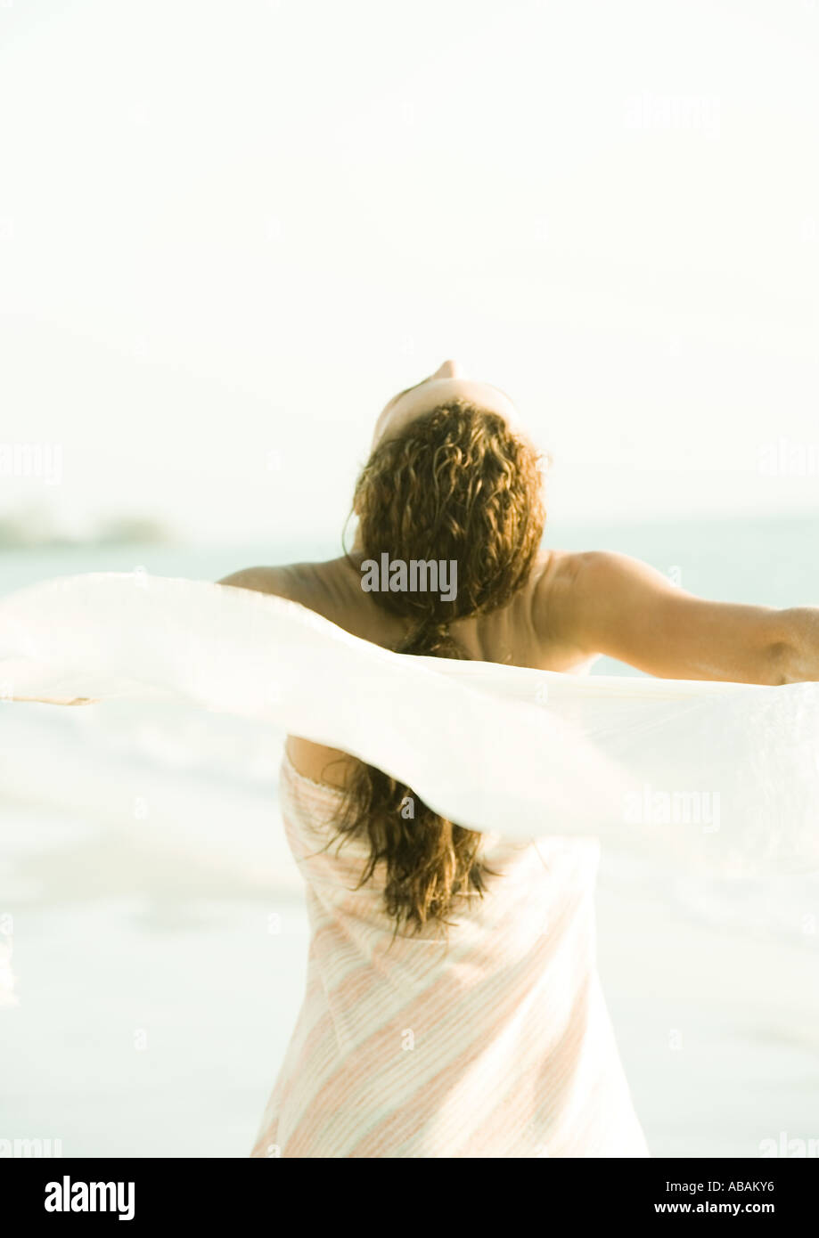Woman throwing head back and spinning around with scarf in wind Stock ...