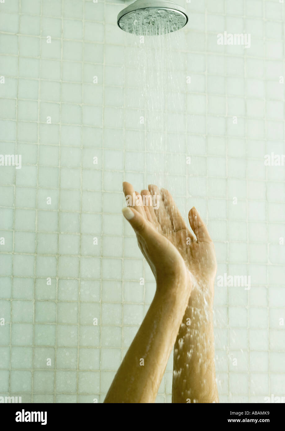 Woman holding up hands under shower Stock Photo - Alamy