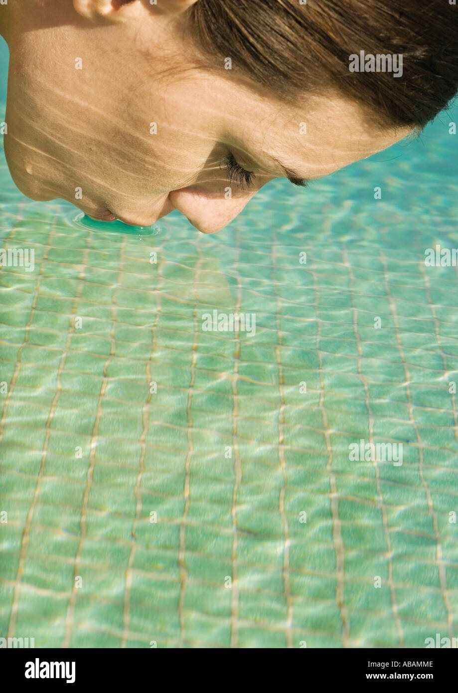 Woman touching lips to surface of water Stock Photo - Alamy