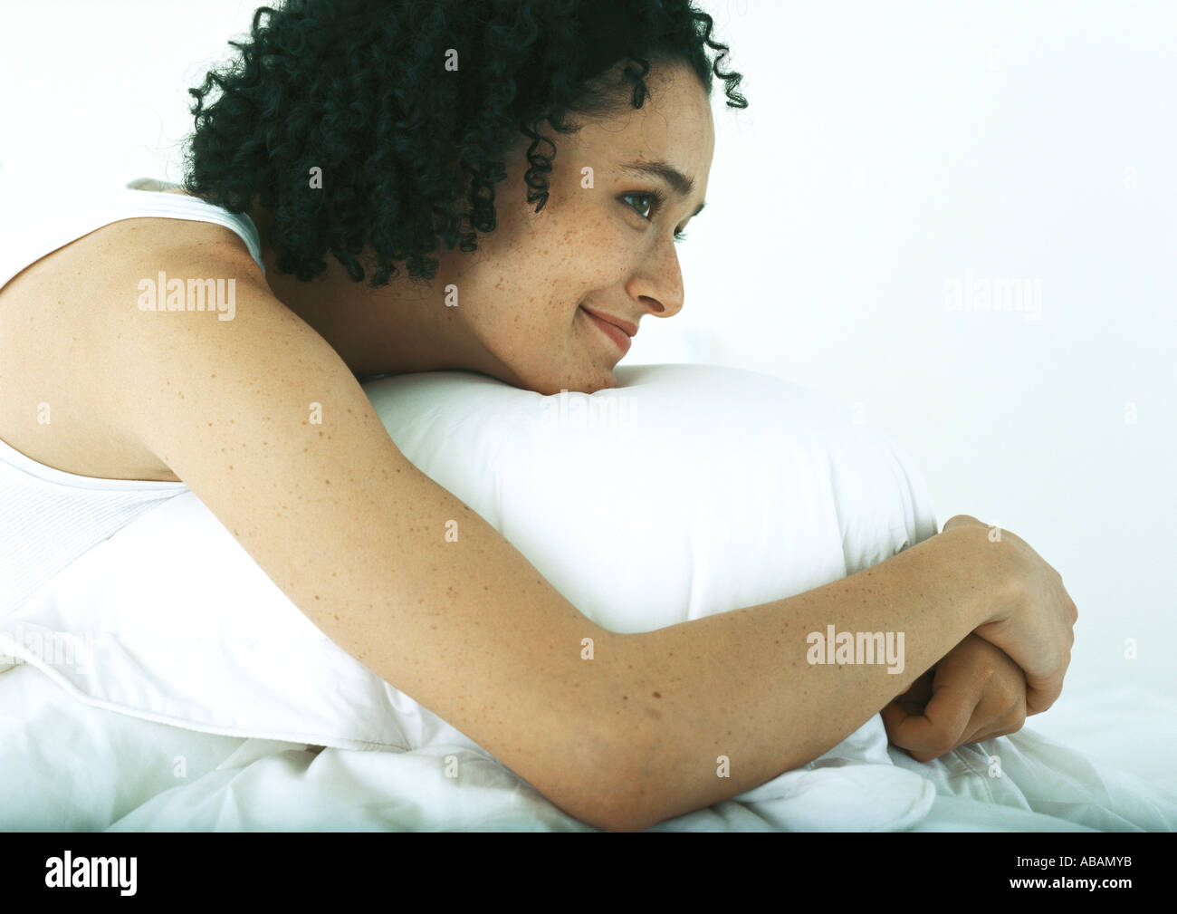 Woman resting head on pillow, smiling Stock Photo - Alamy