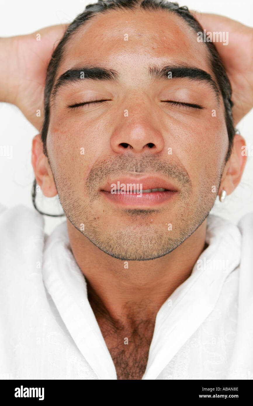 young man with hands on head, closed eyes, relaxing Stock Photo - Alamy
