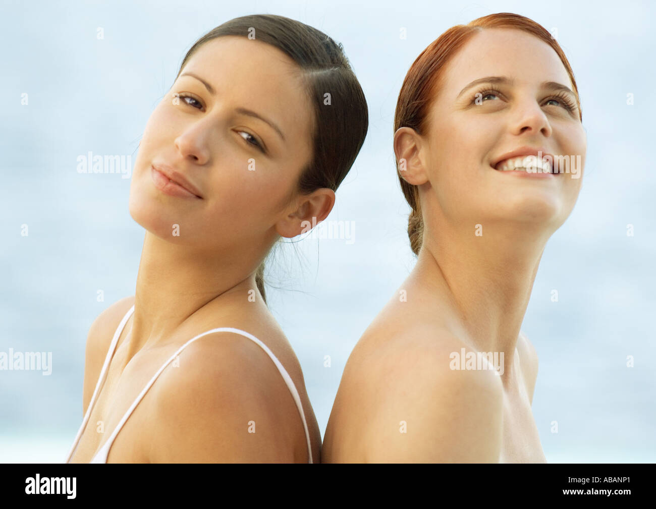 Two young women, back to back, head and shoulders Stock Photo - Alamy