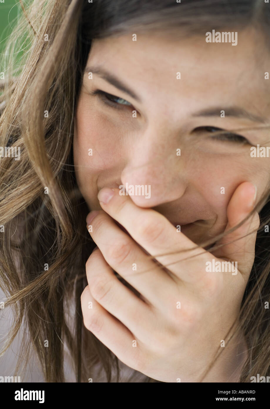 Woman with hand over mouth Stock Photo - Alamy
